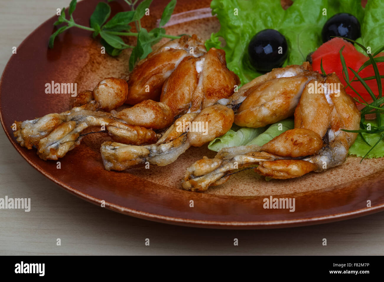 Roasted Frog legs with herbs and spices Stock Photo - Alamy