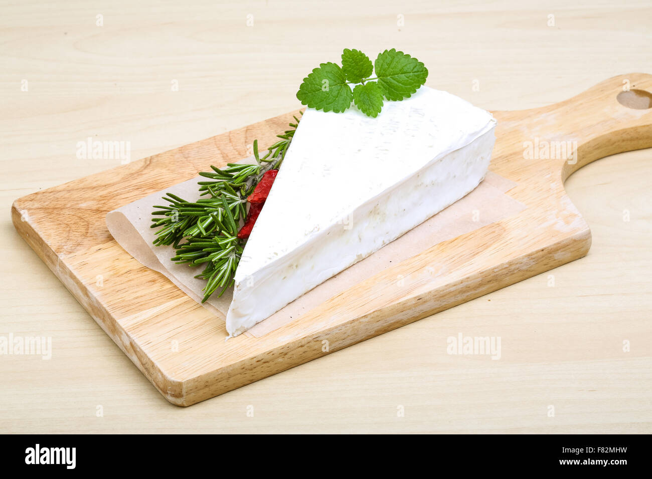 Soft brie cheese with rosemary, thyme on the wood background Stock ...