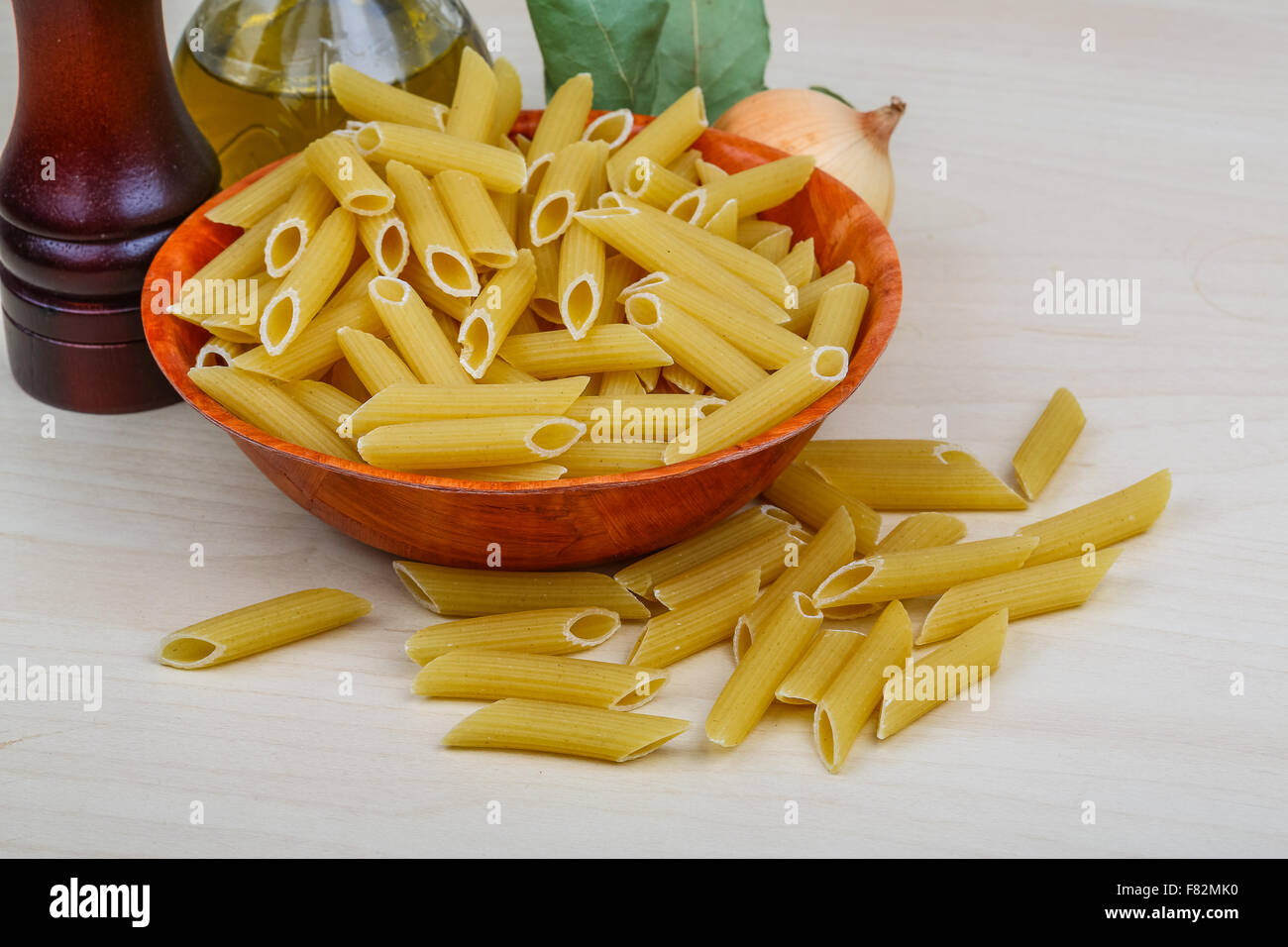 Raw penne in the bowl with olive oil Stock Photo - Alamy