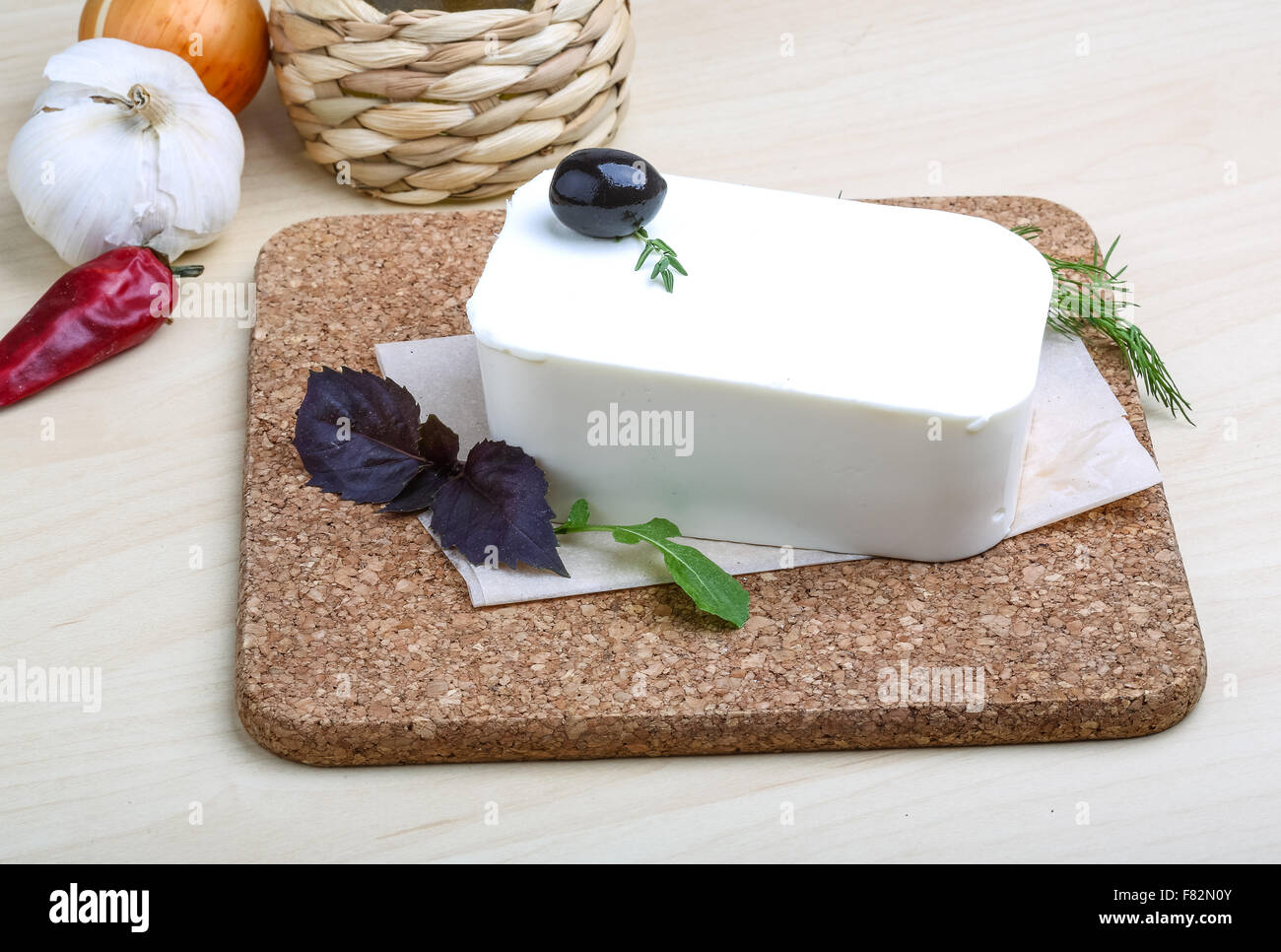 Feta cheese slice on the board with herbs Stock Photo - Alamy