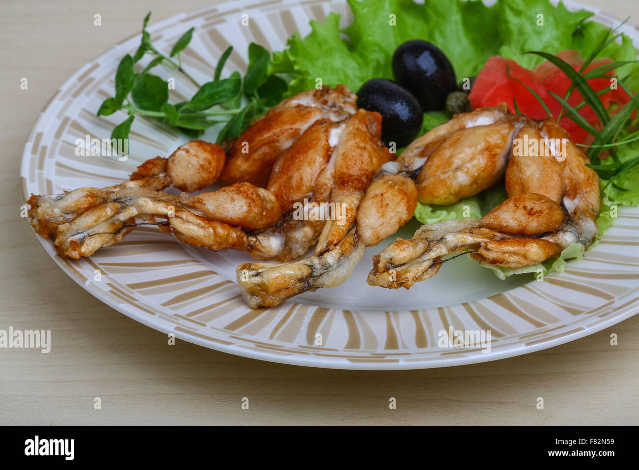 Roasted Frog legs with herbs and spices Stock Photo - Alamy