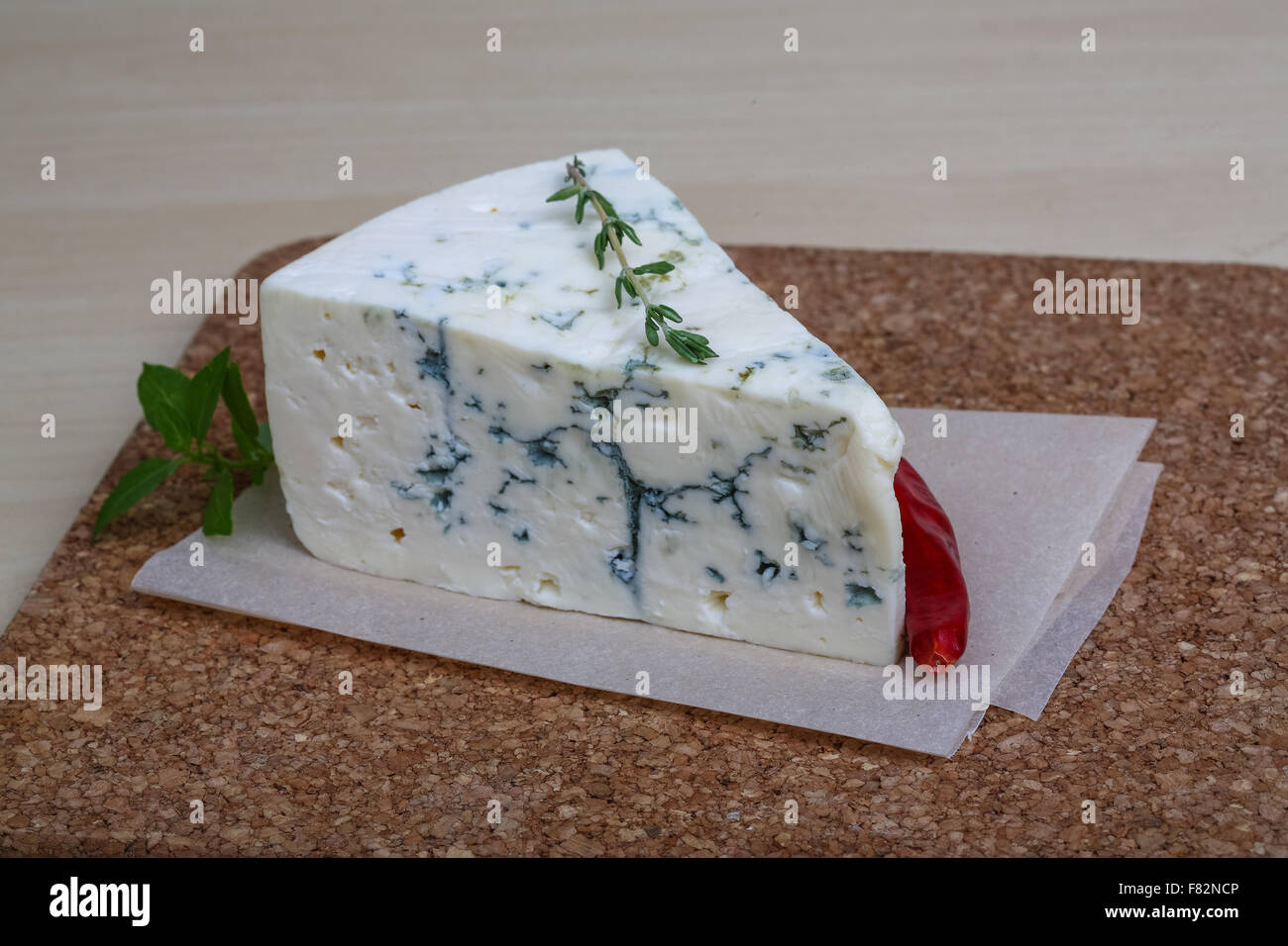 Blue cheese with basil leaves on the wood background Stock Photo - Alamy
