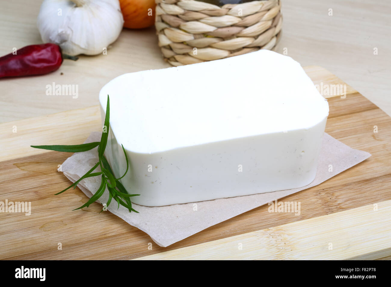 Feta cheese slice on the board with terragon Stock Photo - Alamy