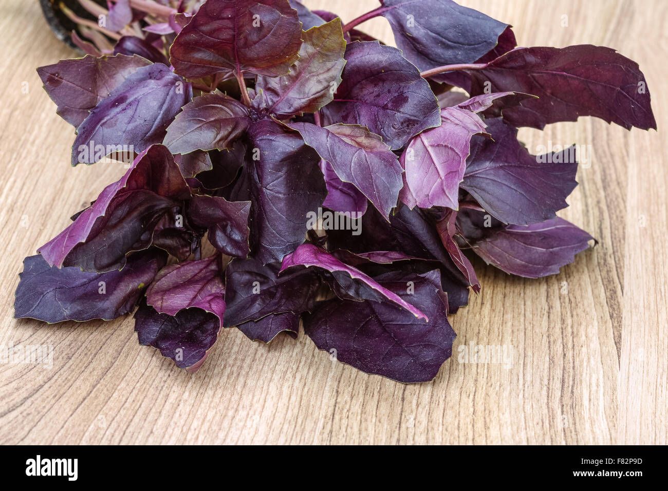 Fresh violet Basil leaves heap on the wood background Stock Photo - Alamy