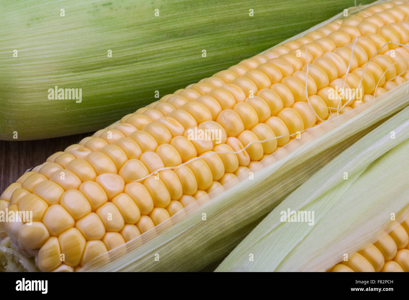 Sweet raw fresh corn on the wood background Stock Photo - Alamy