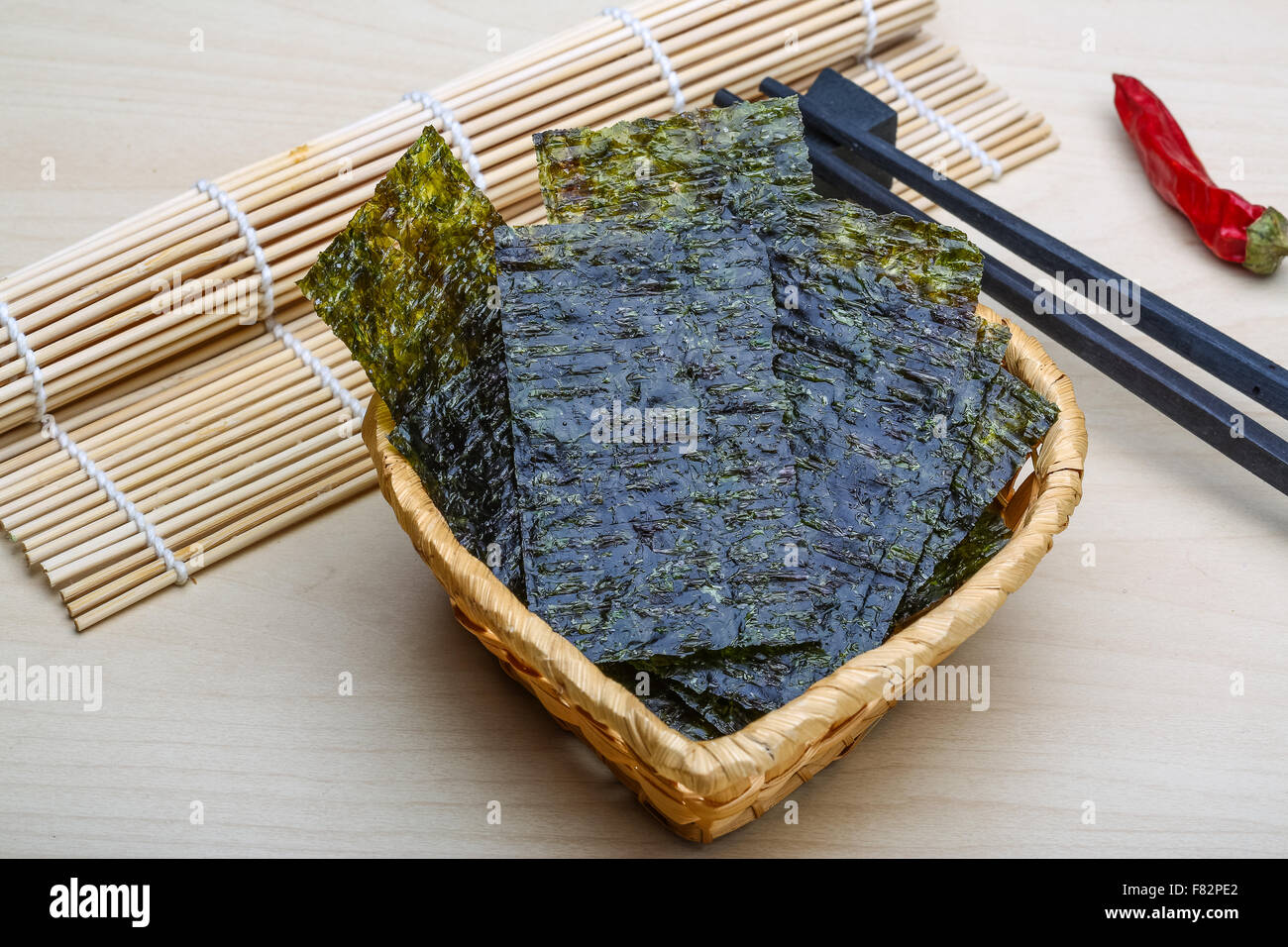Nori sheets with sticks on the wood background Stock Photo - Alamy