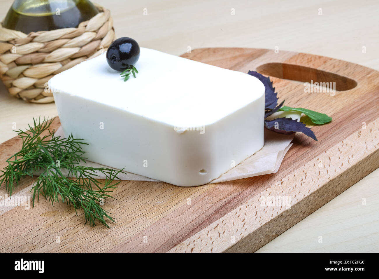 Feta cheese slice on the board with herbs Stock Photo - Alamy