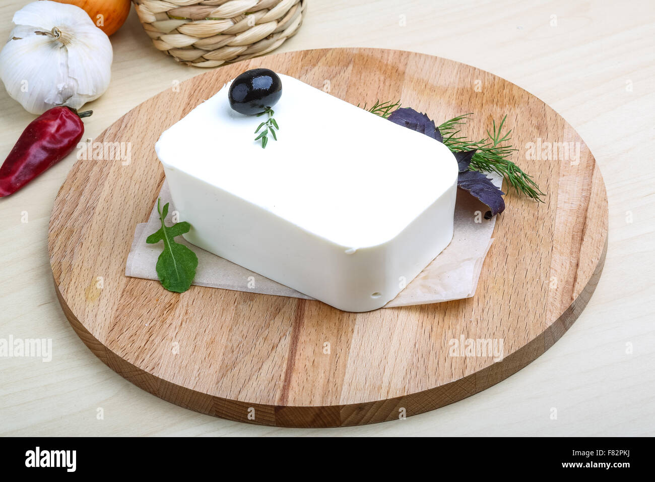 Feta cheese slice on the board with herbs Stock Photo - Alamy
