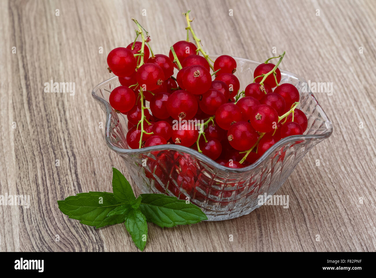 Fresh bright Red currant on the wood background with mint leaves Stock ...