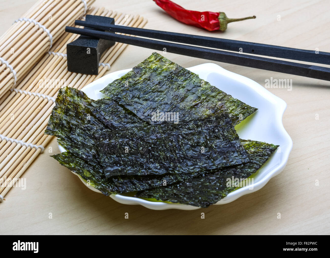 Nori sheets with sticks on the wood background Stock Photo - Alamy