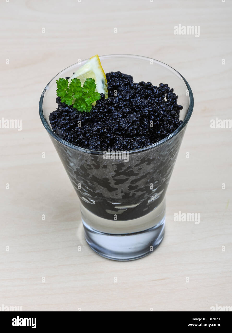 Luxury Black caviar with green herb and lemon Stock Photo - Alamy