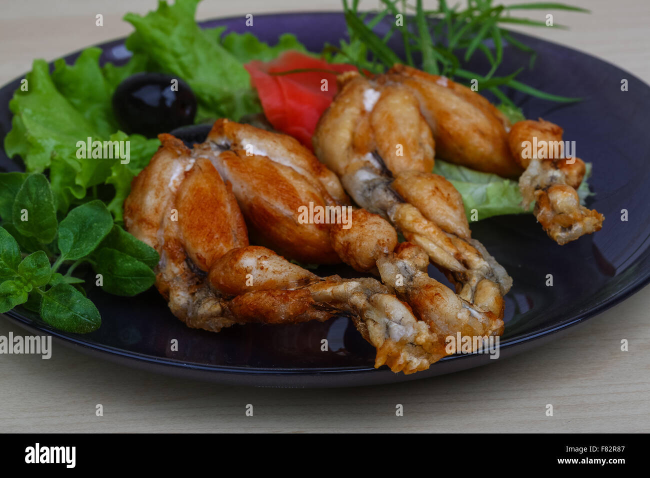 Roasted Frog legs with herbs and spices Stock Photo - Alamy