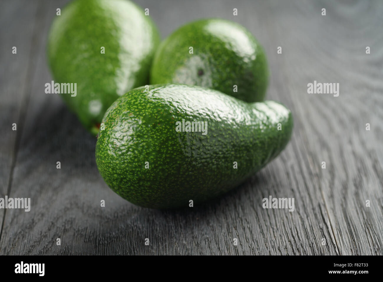 ripe green avocados on wood table Stock Photo - Alamy