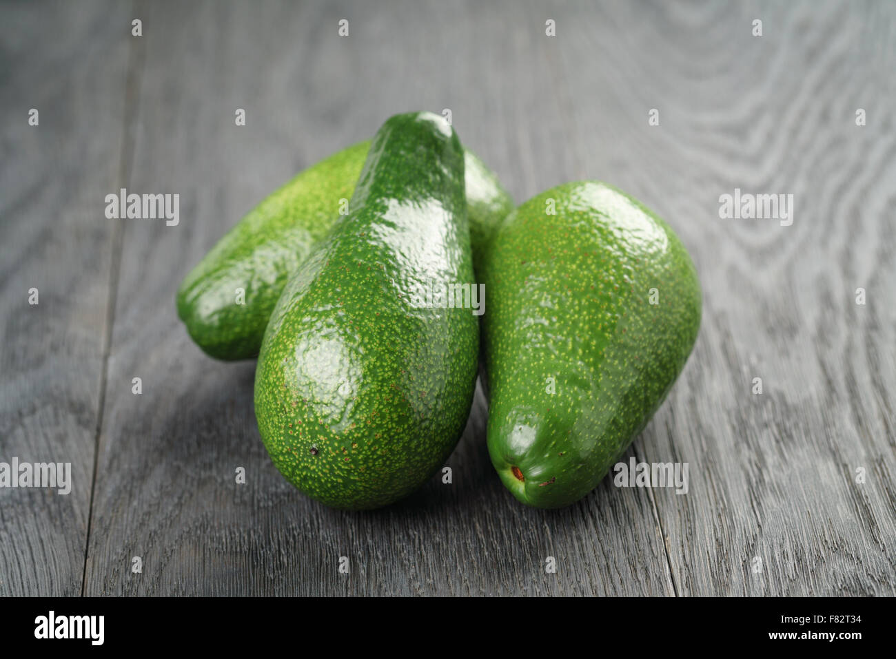 ripe green avocados on wood table Stock Photo - Alamy
