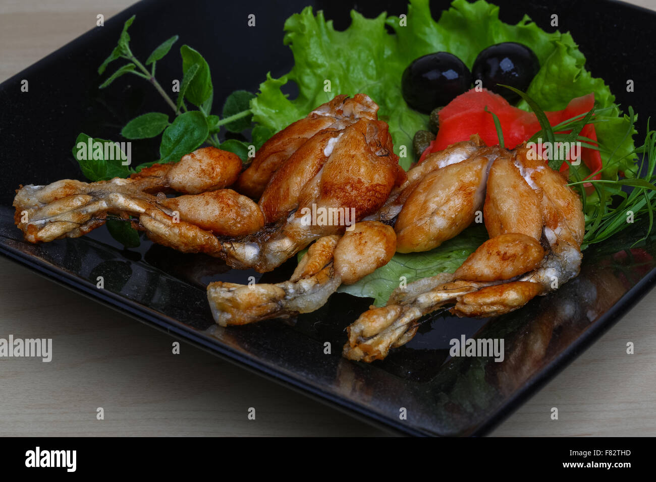 Roasted Frog legs with herbs and spices Stock Photo - Alamy
