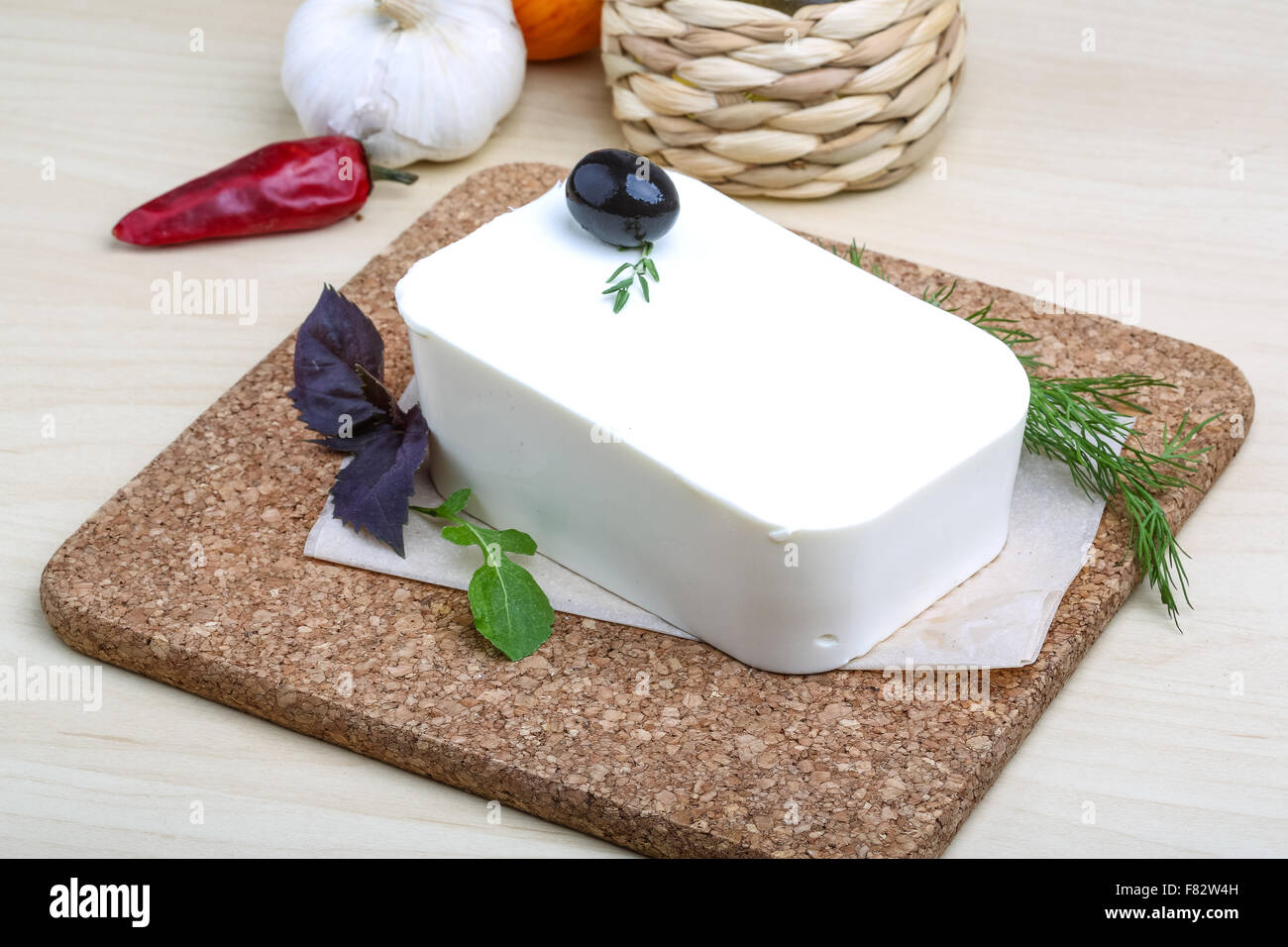 Feta cheese slice on the board with herbs Stock Photo - Alamy