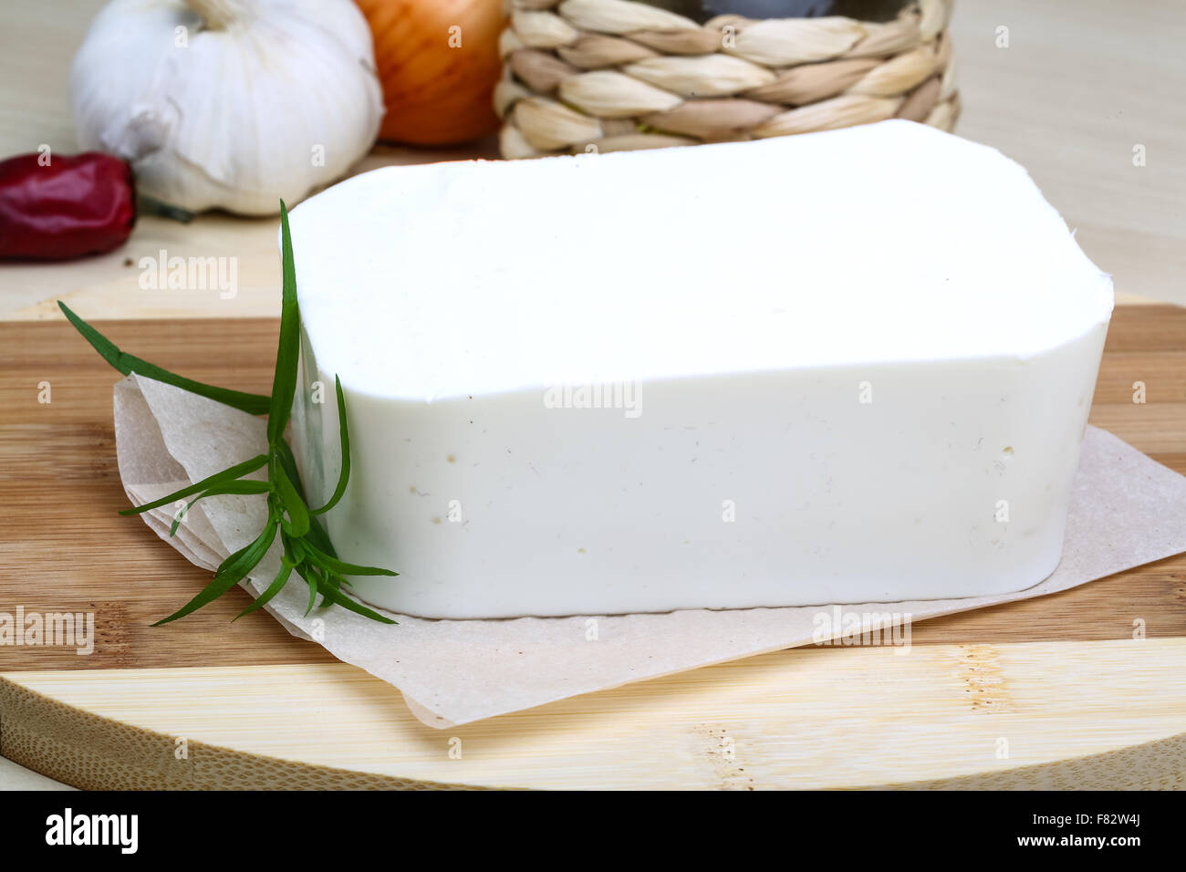 Feta cheese slice on the board with terragon Stock Photo - Alamy