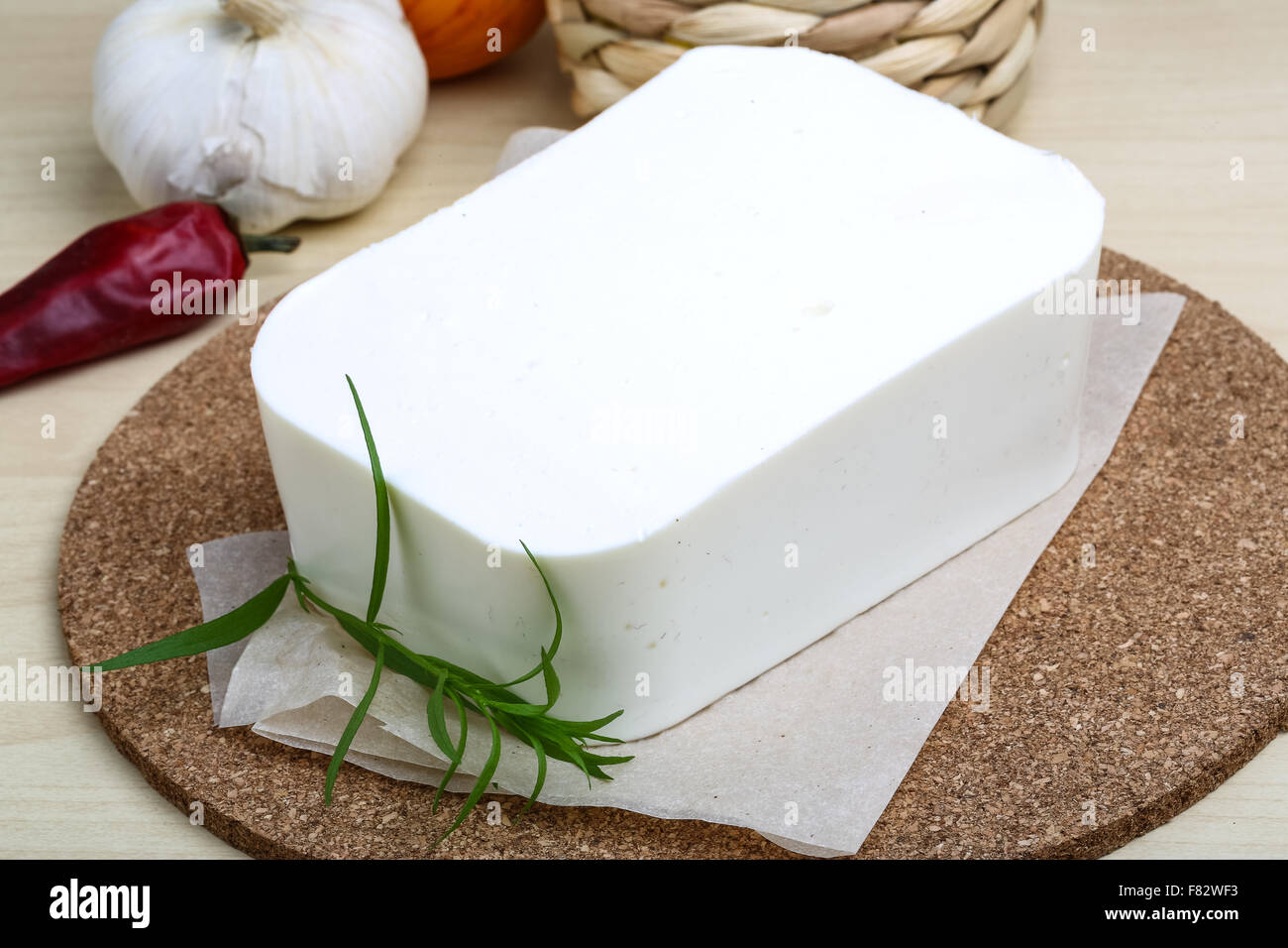 Feta cheese slice on the board with terragon Stock Photo - Alamy