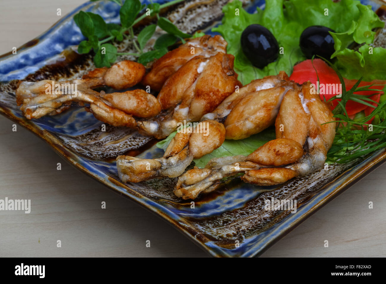 Roasted Frog legs with herbs and spices Stock Photo - Alamy