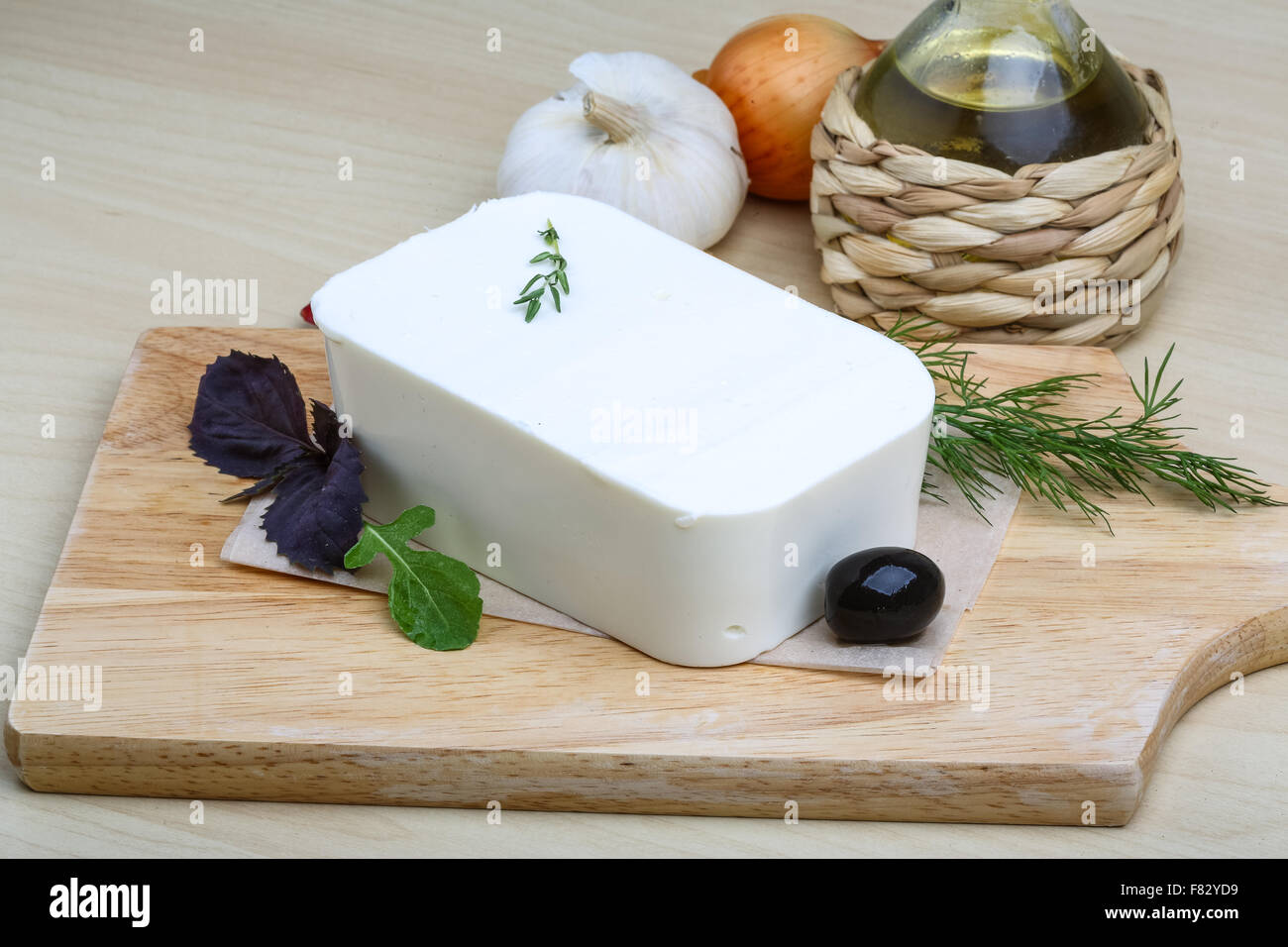 Feta cheese slice on the board with herbs Stock Photo - Alamy
