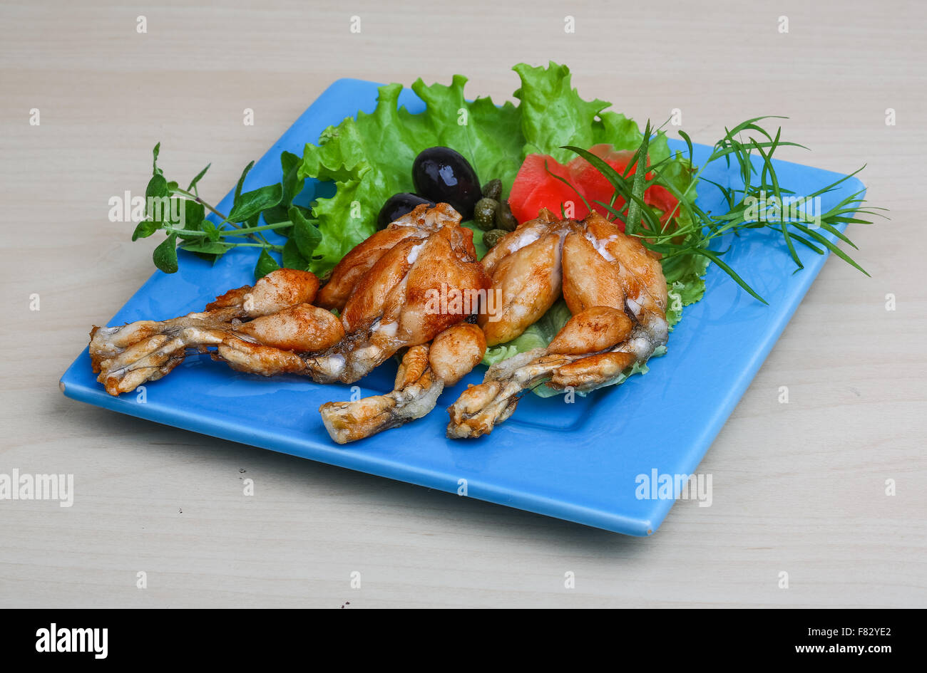 Fried frog legs with olive, herbs and spices Stock Photo - Alamy