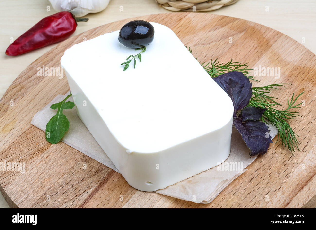 Feta cheese slice on the board with herbs Stock Photo - Alamy