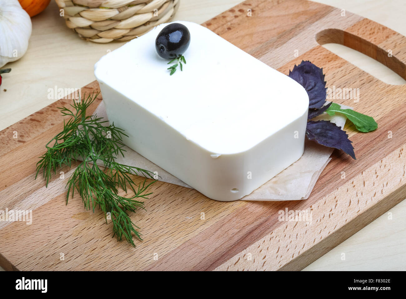 Feta cheese slice on the board with herbs Stock Photo - Alamy