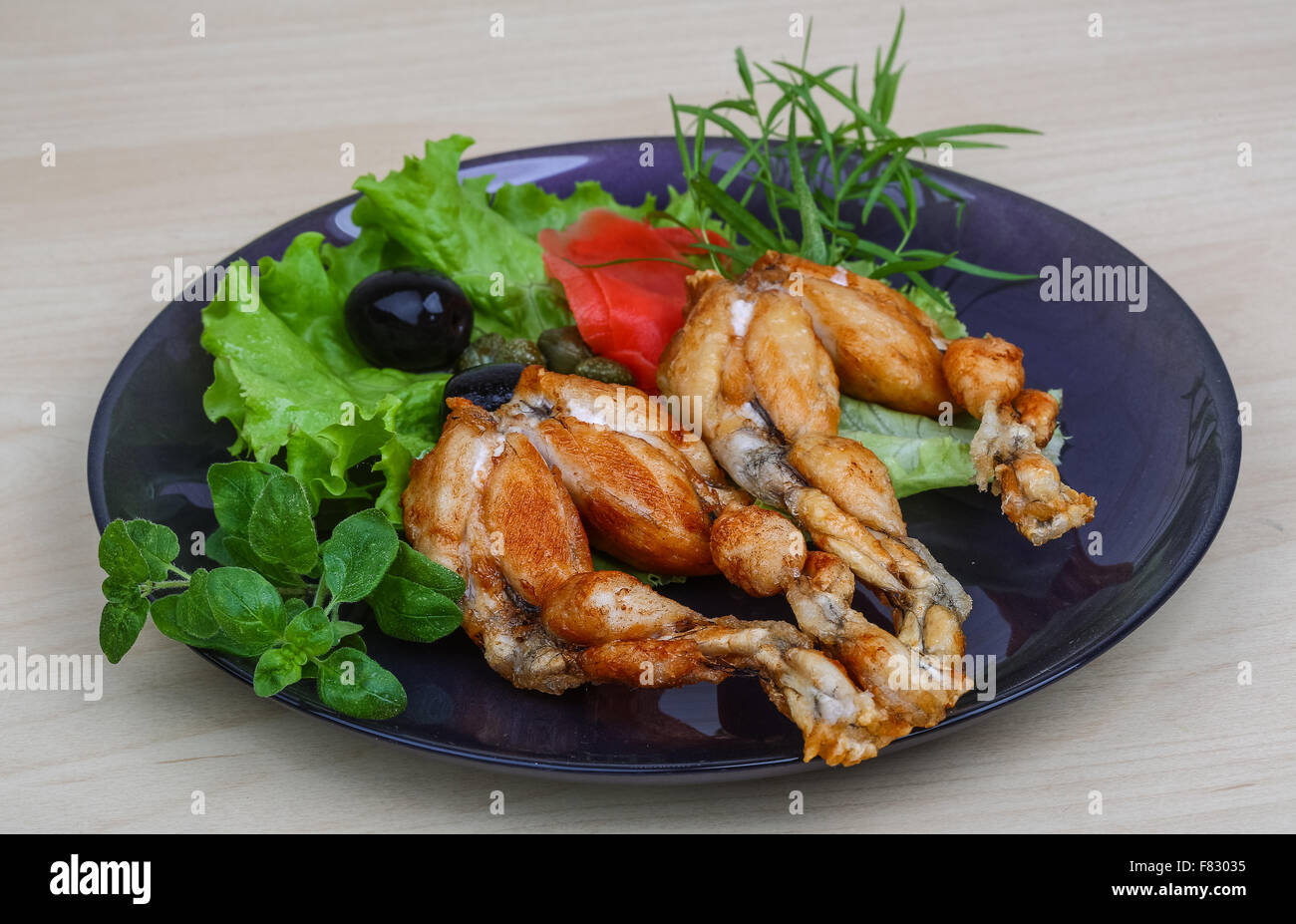 Roasted Frog legs with herbs and spices Stock Photo - Alamy