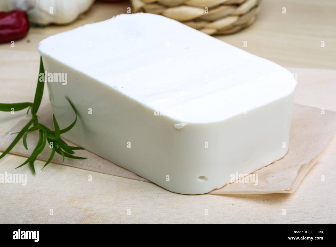 Feta cheese slice on the board with herbs Stock Photo - Alamy