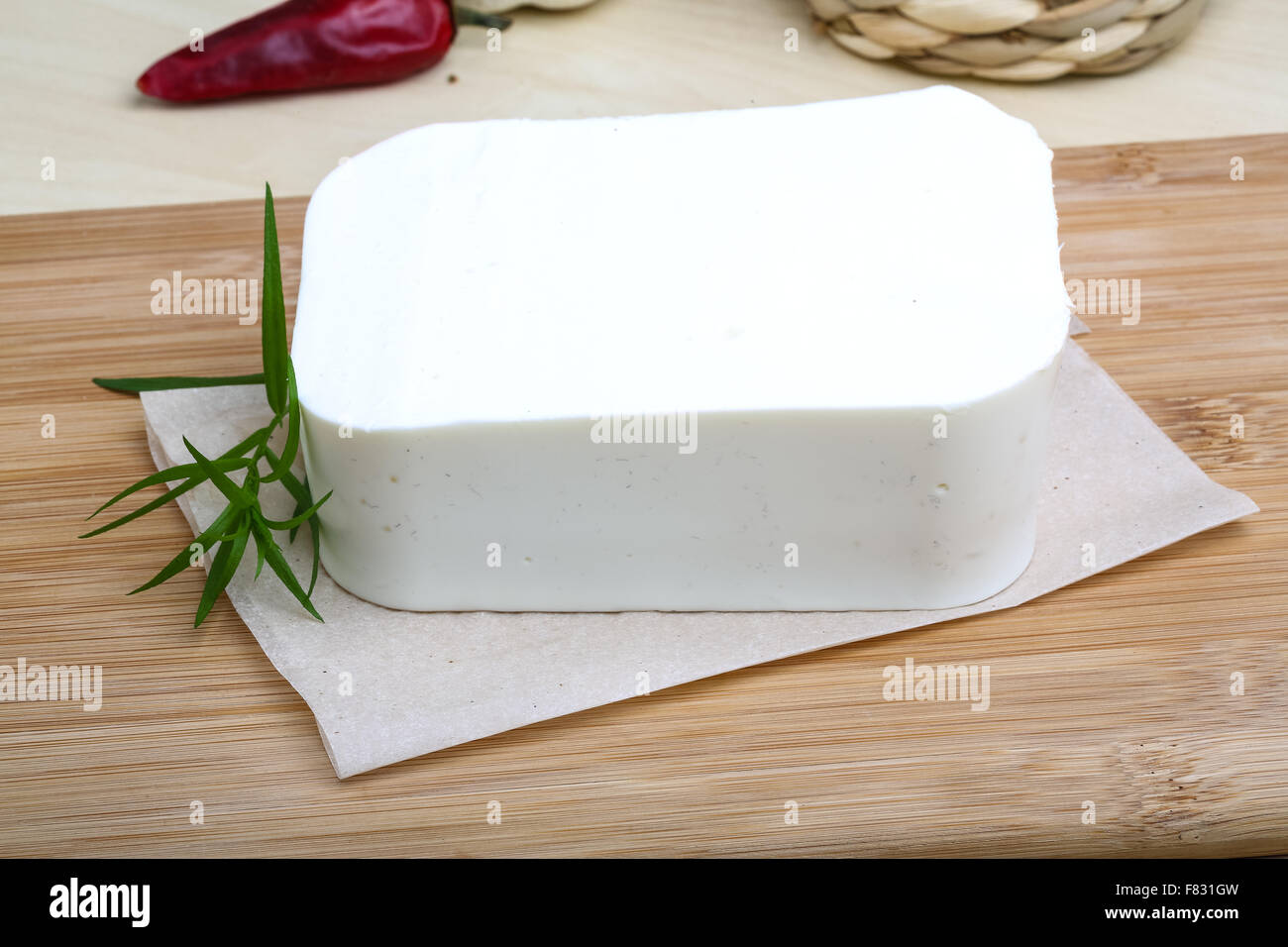 Feta cheese slice on the board with herbs Stock Photo - Alamy