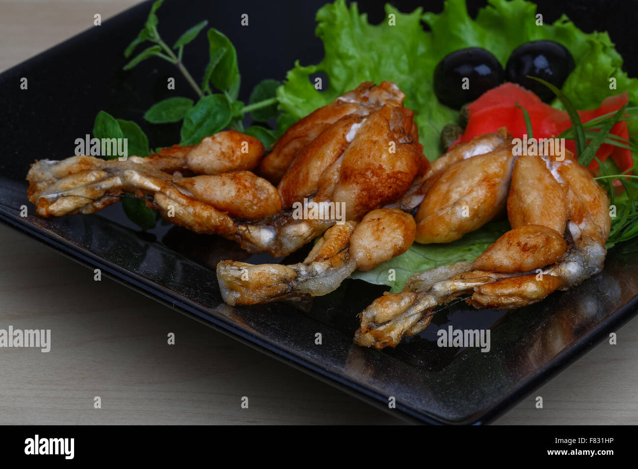 Roasted Frog legs with herbs and spices Stock Photo - Alamy