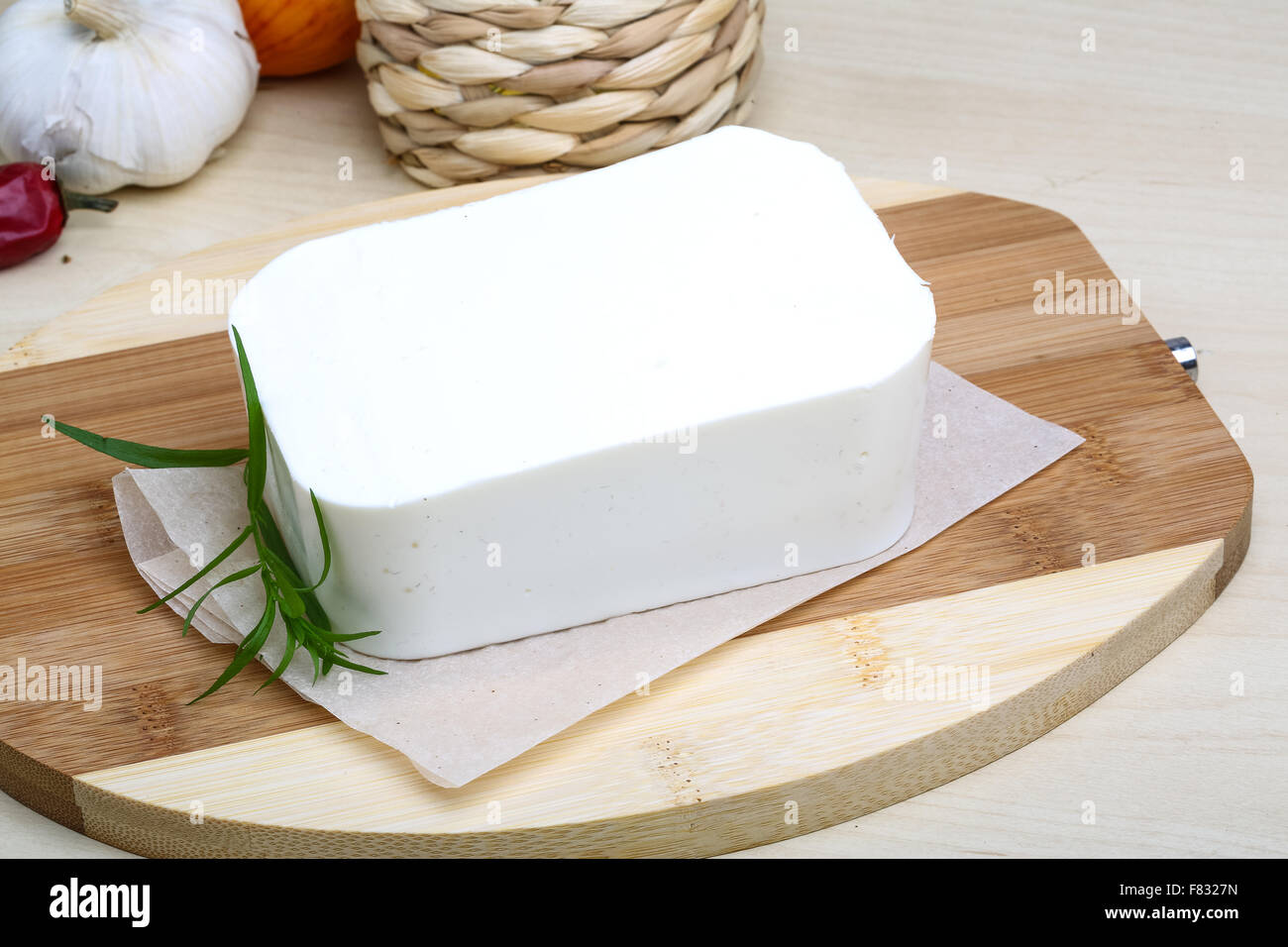Feta cheese slice on the board with terragon Stock Photo - Alamy