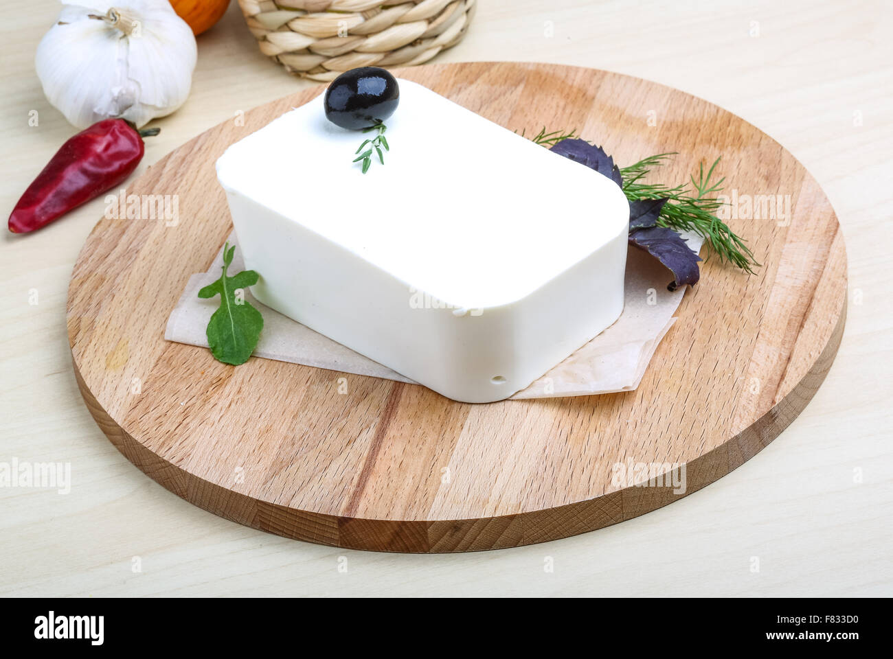 Feta cheese slice on the board with herbs Stock Photo - Alamy