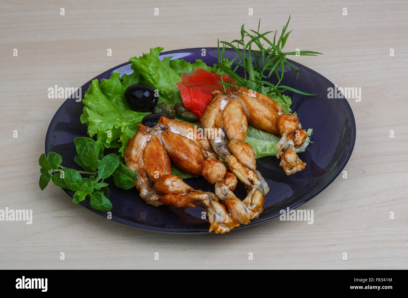 Roasted Frog legs with herbs and spices Stock Photo - Alamy