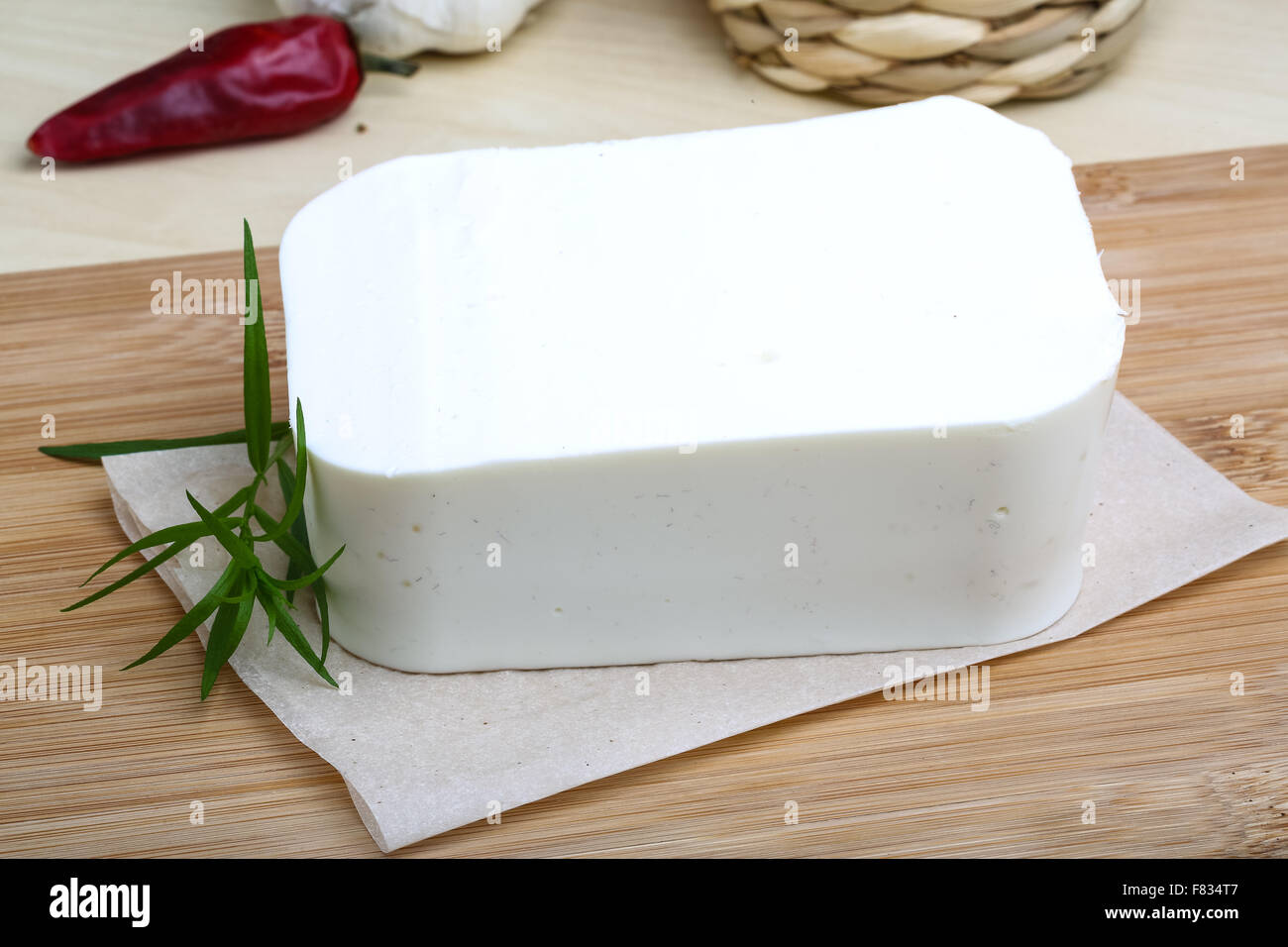 Feta cheese slice on the board with herbs Stock Photo - Alamy