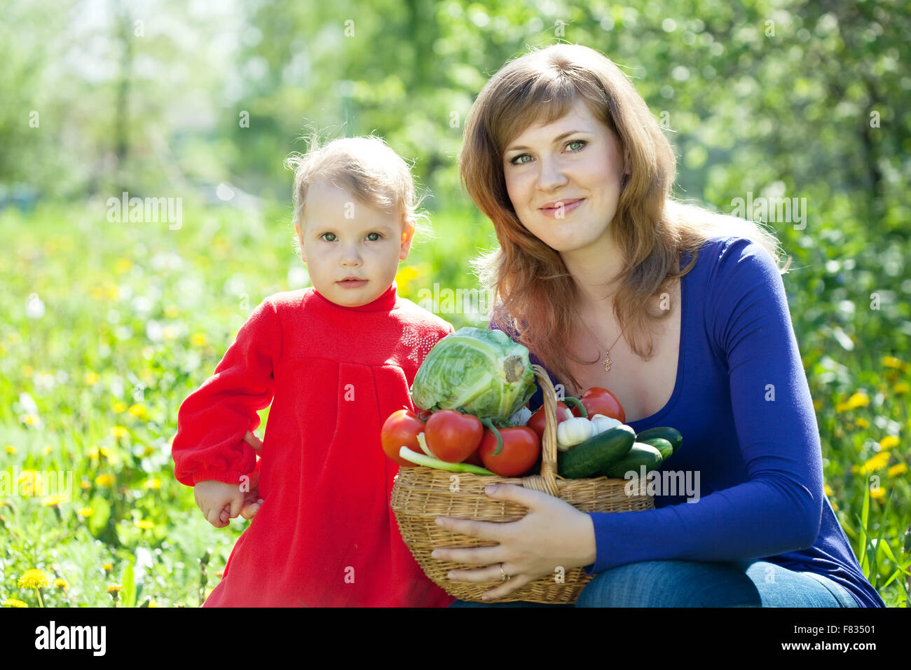 Happy famile with vegetables harvest in garden Stock Photo - Alamy