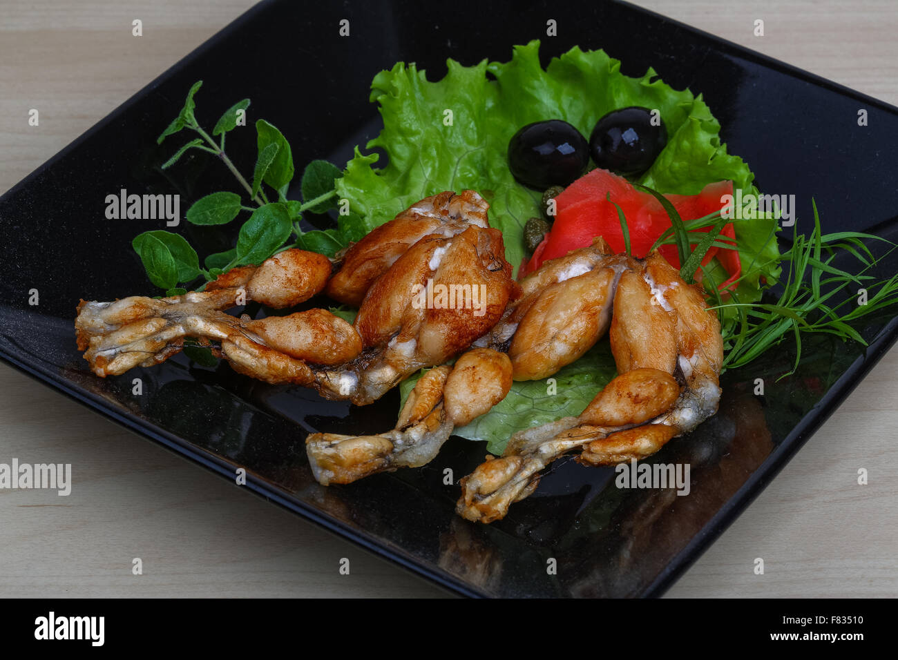 Roasted Frog legs with herbs and spices Stock Photo - Alamy