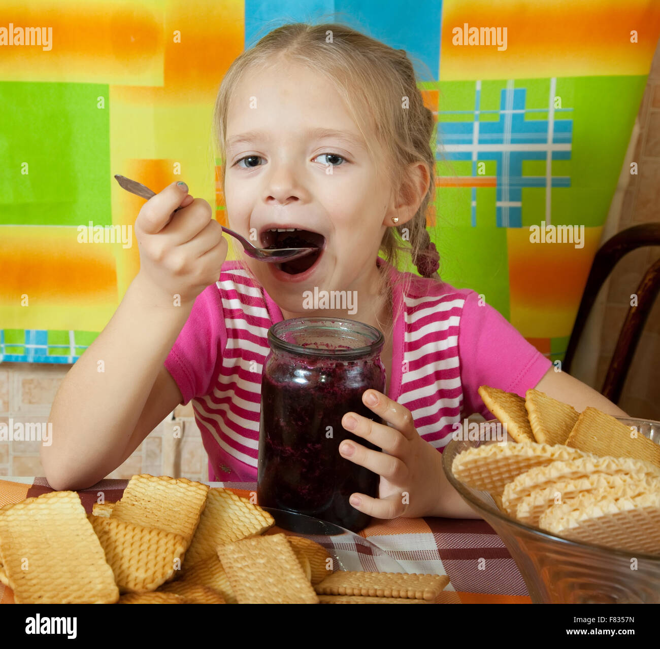 Little girl eating jam from jar at kitchen Stock Photo - Alamy