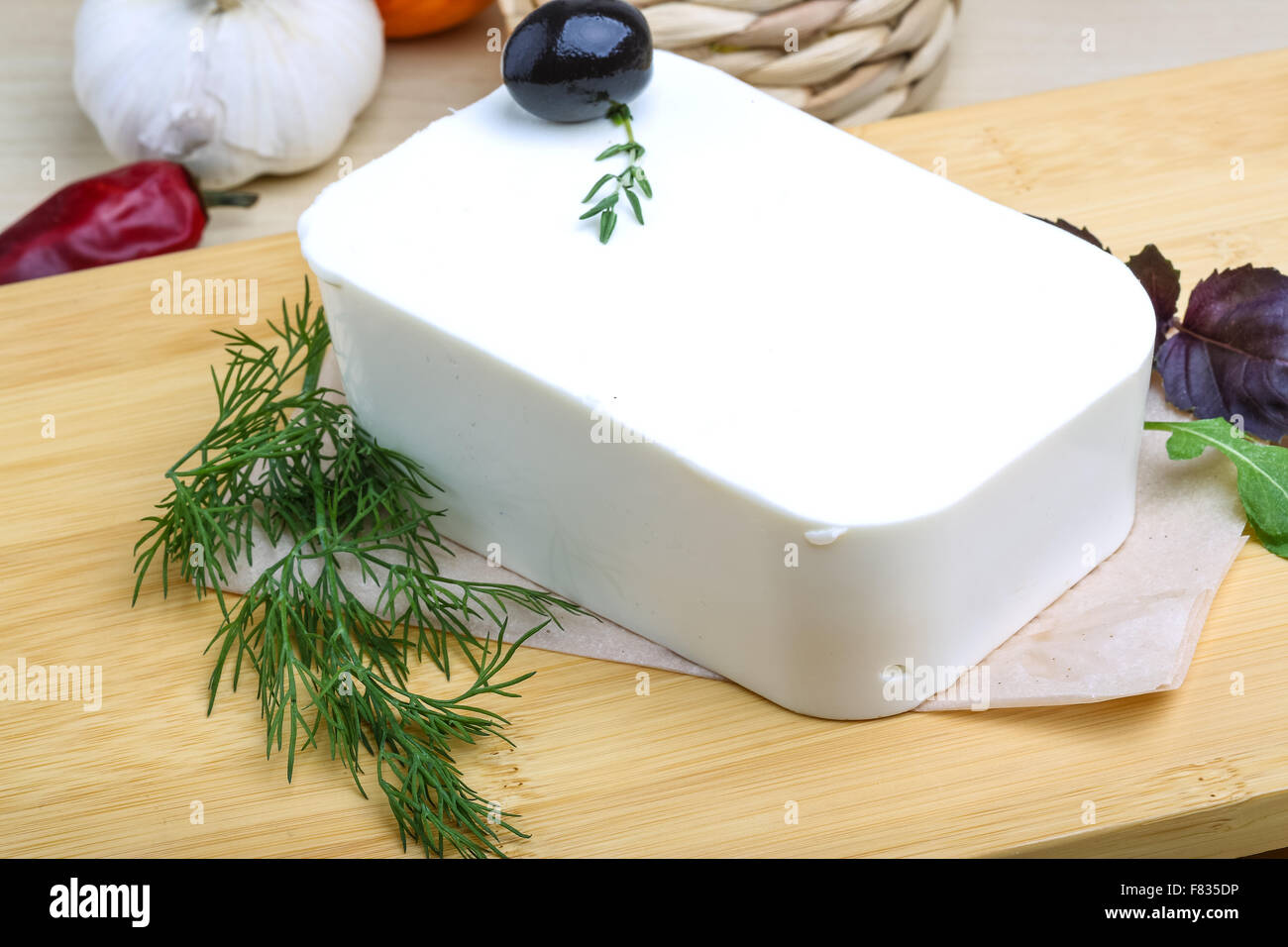 Feta cheese slice on the board with herbs Stock Photo - Alamy