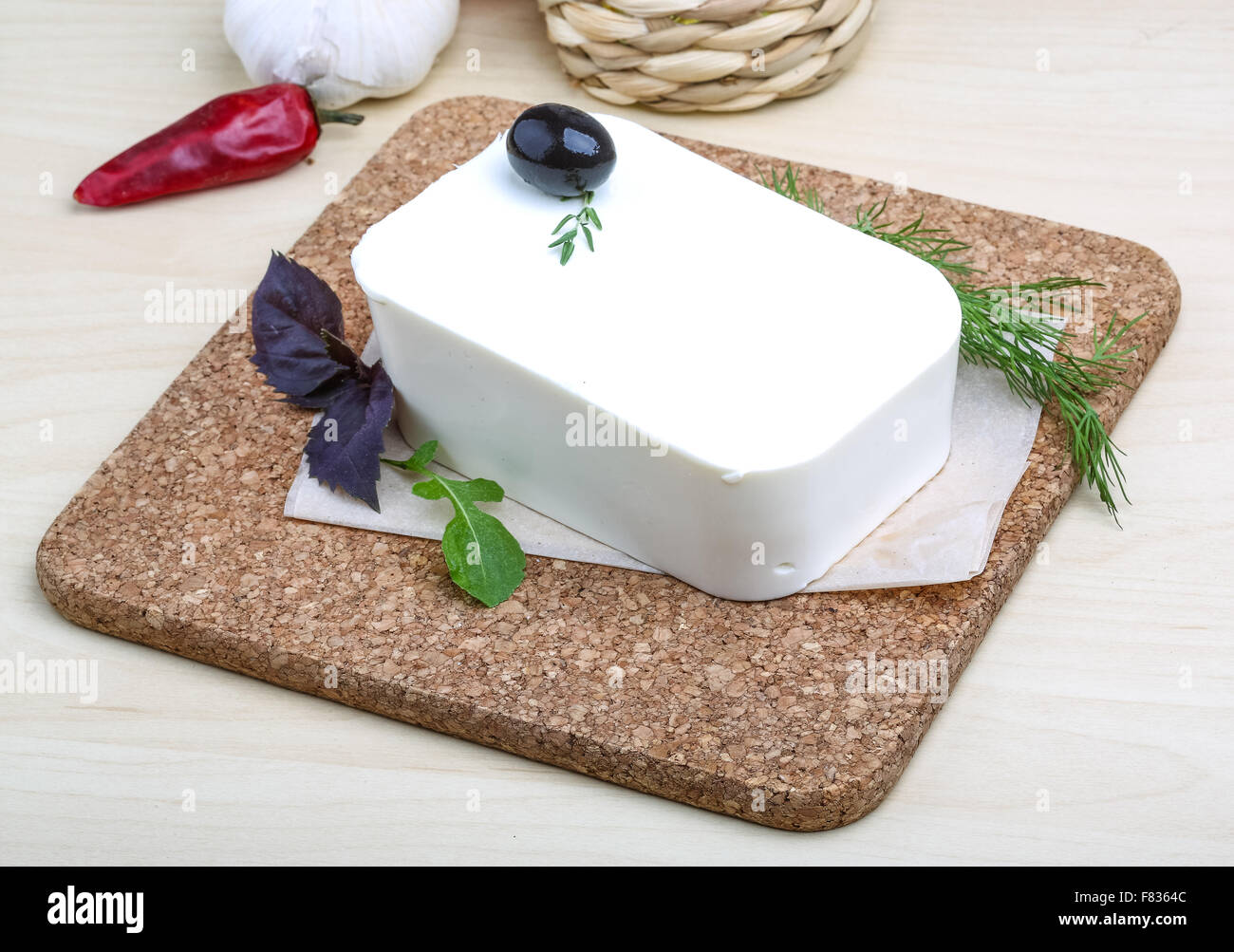 Feta cheese slice on the board with herbs Stock Photo - Alamy