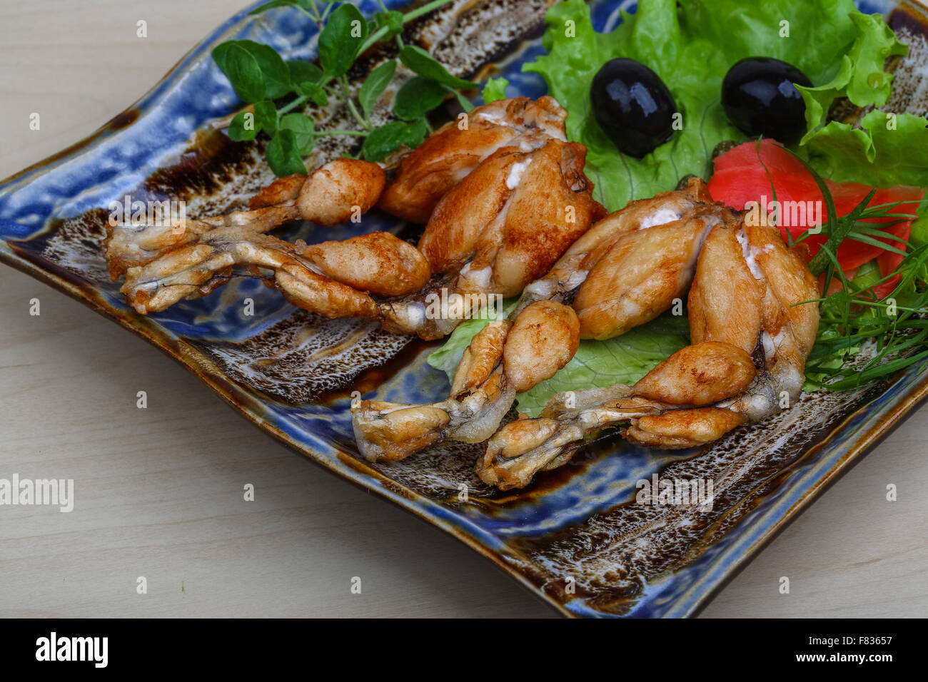 Roasted Frog legs with herbs and spices Stock Photo - Alamy