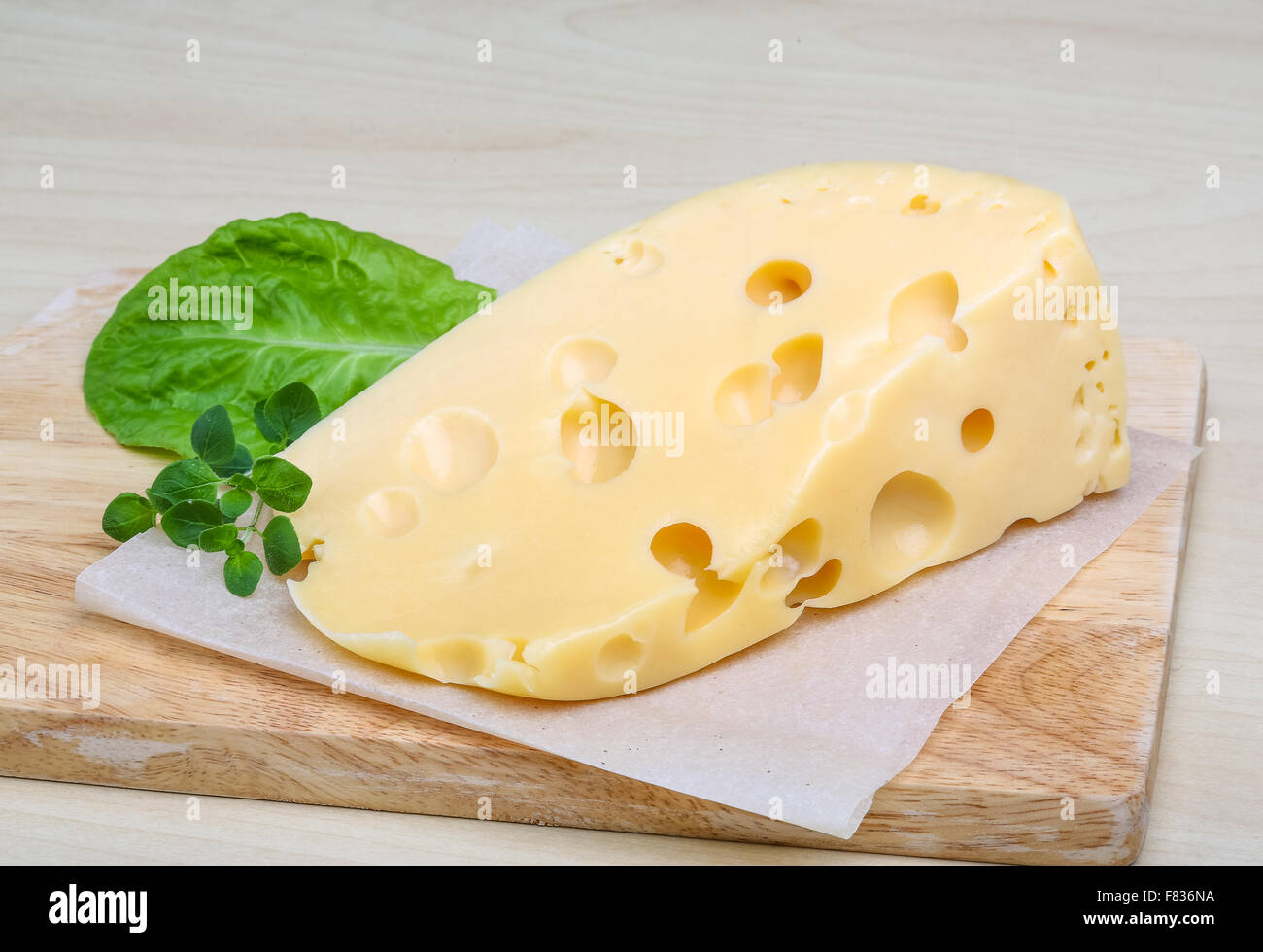 Yellow cheese with oregano leaves on the wood background Stock Photo ...