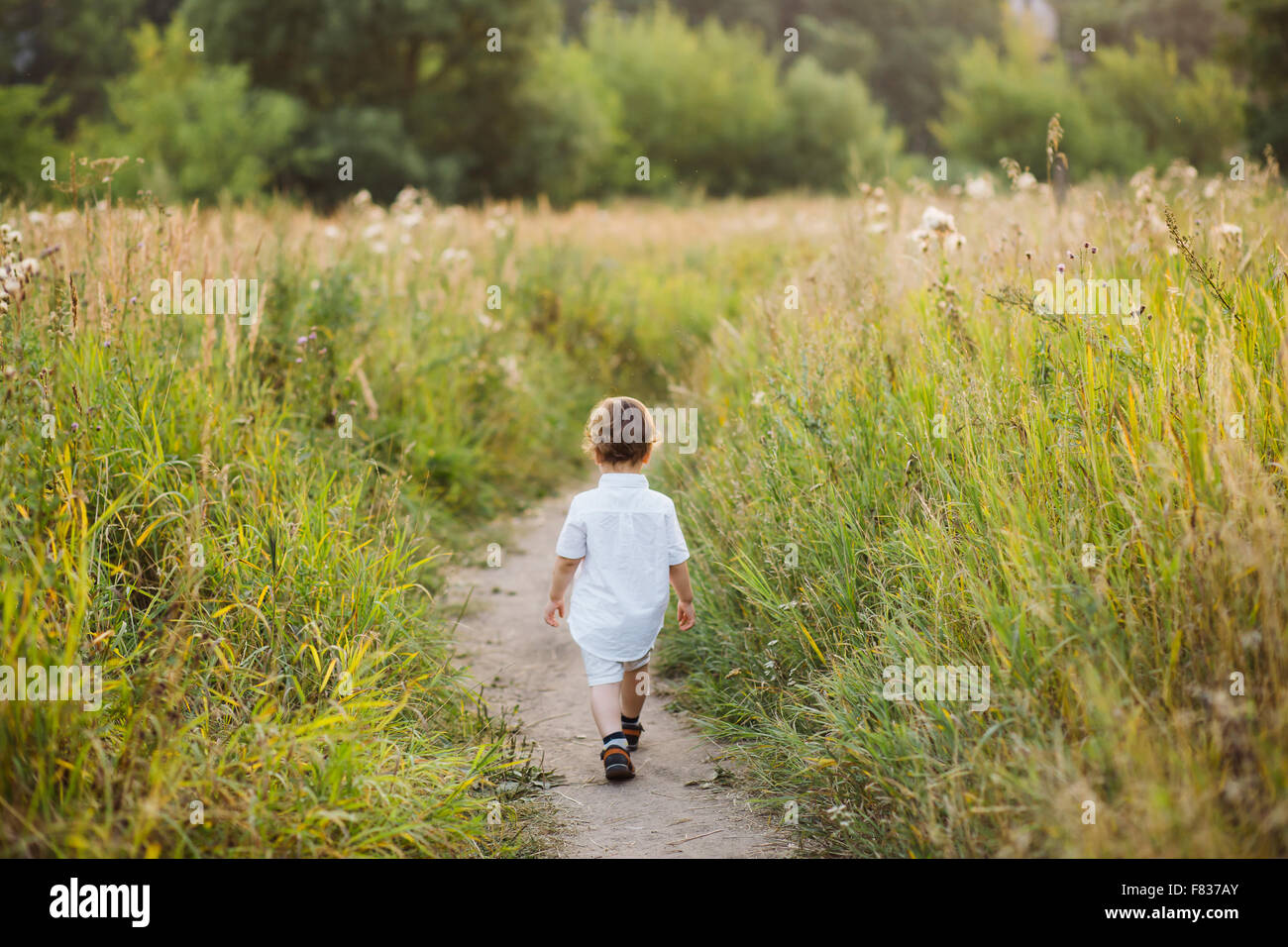 Little boy waling by the stone road Stock Photo - Alamy