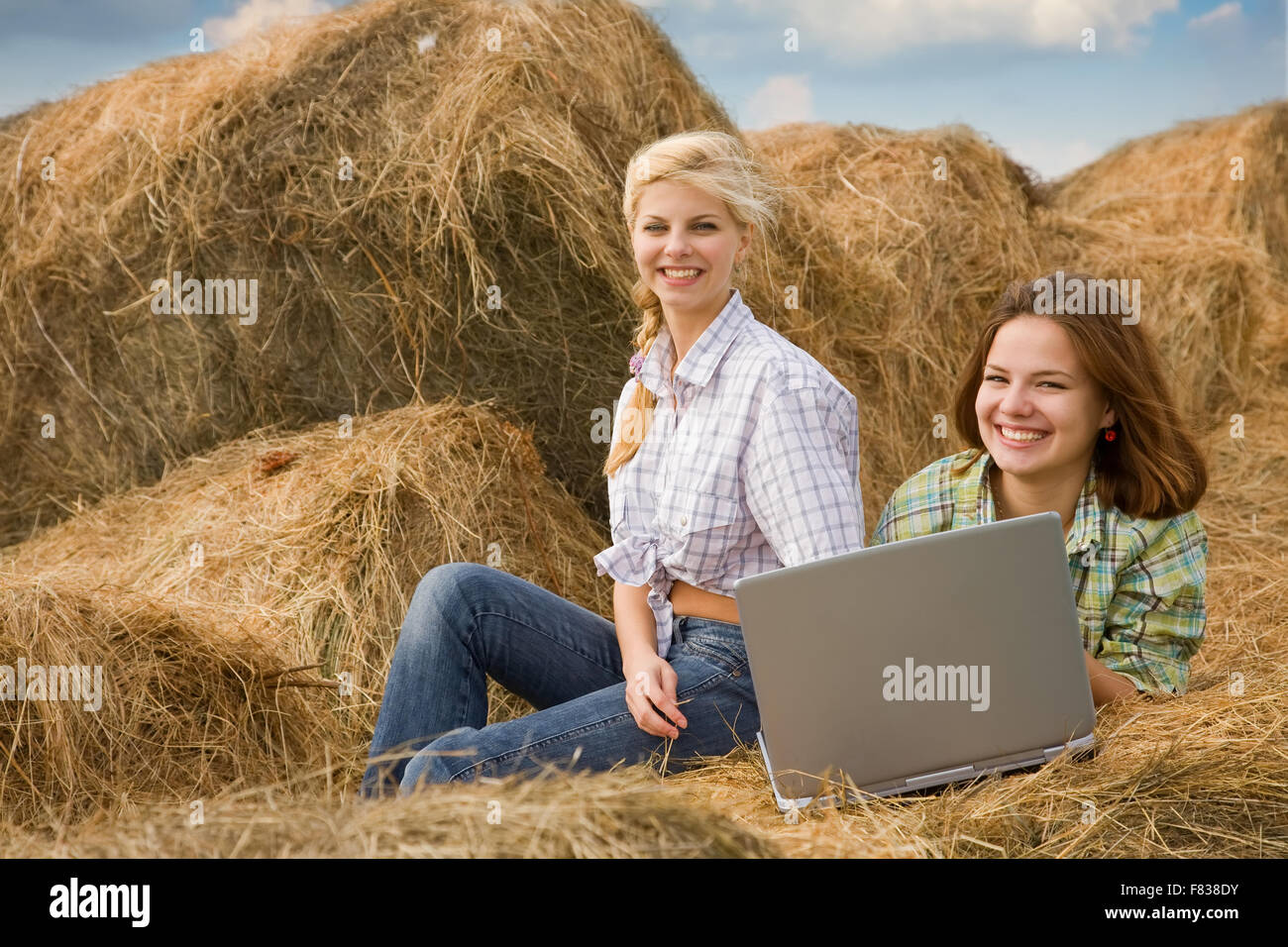 country girls with laptop on hay at field Stock Photo - Alamy