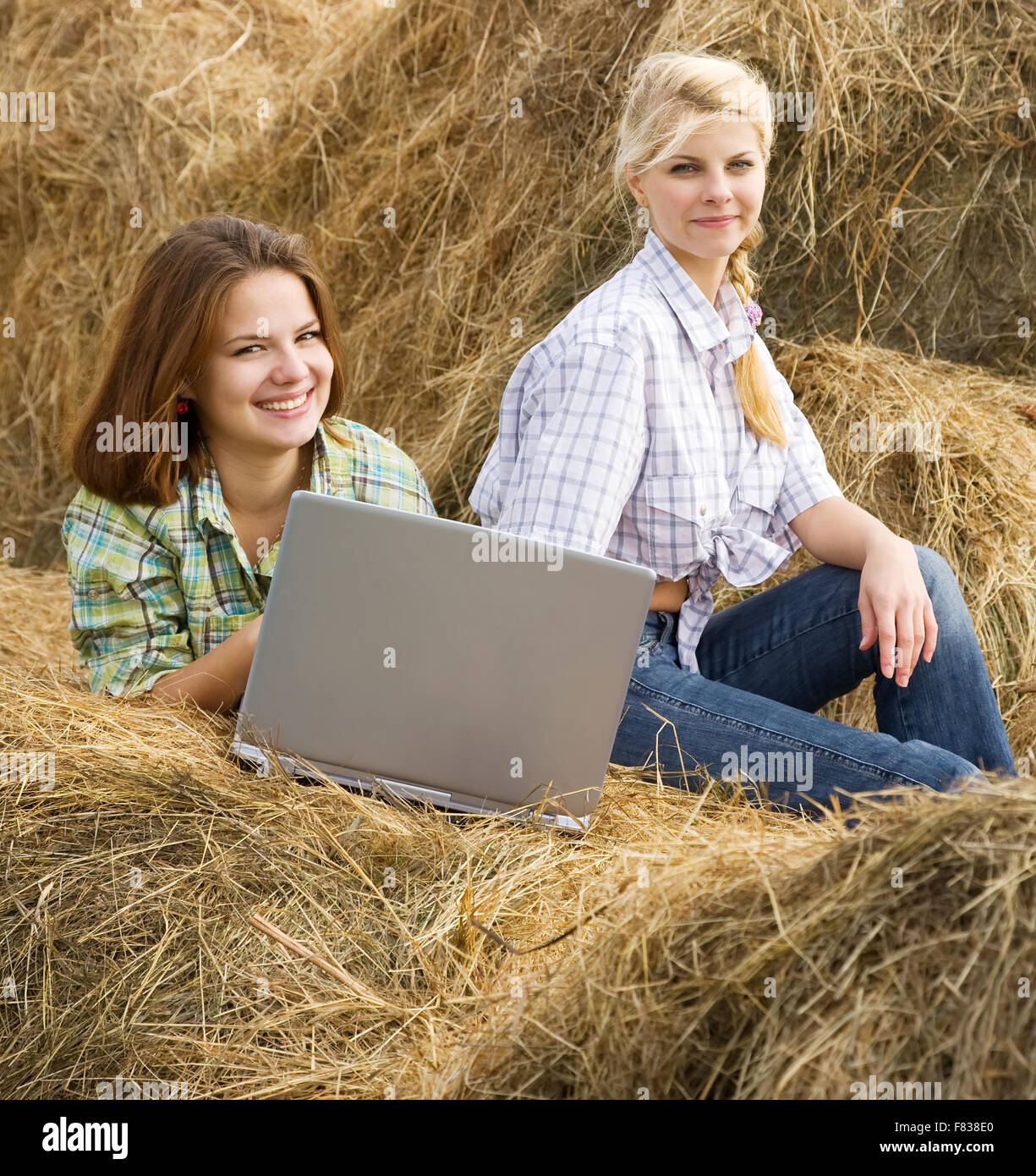country girls resting with laptop on fresh hay bale Stock Photo - Alamy