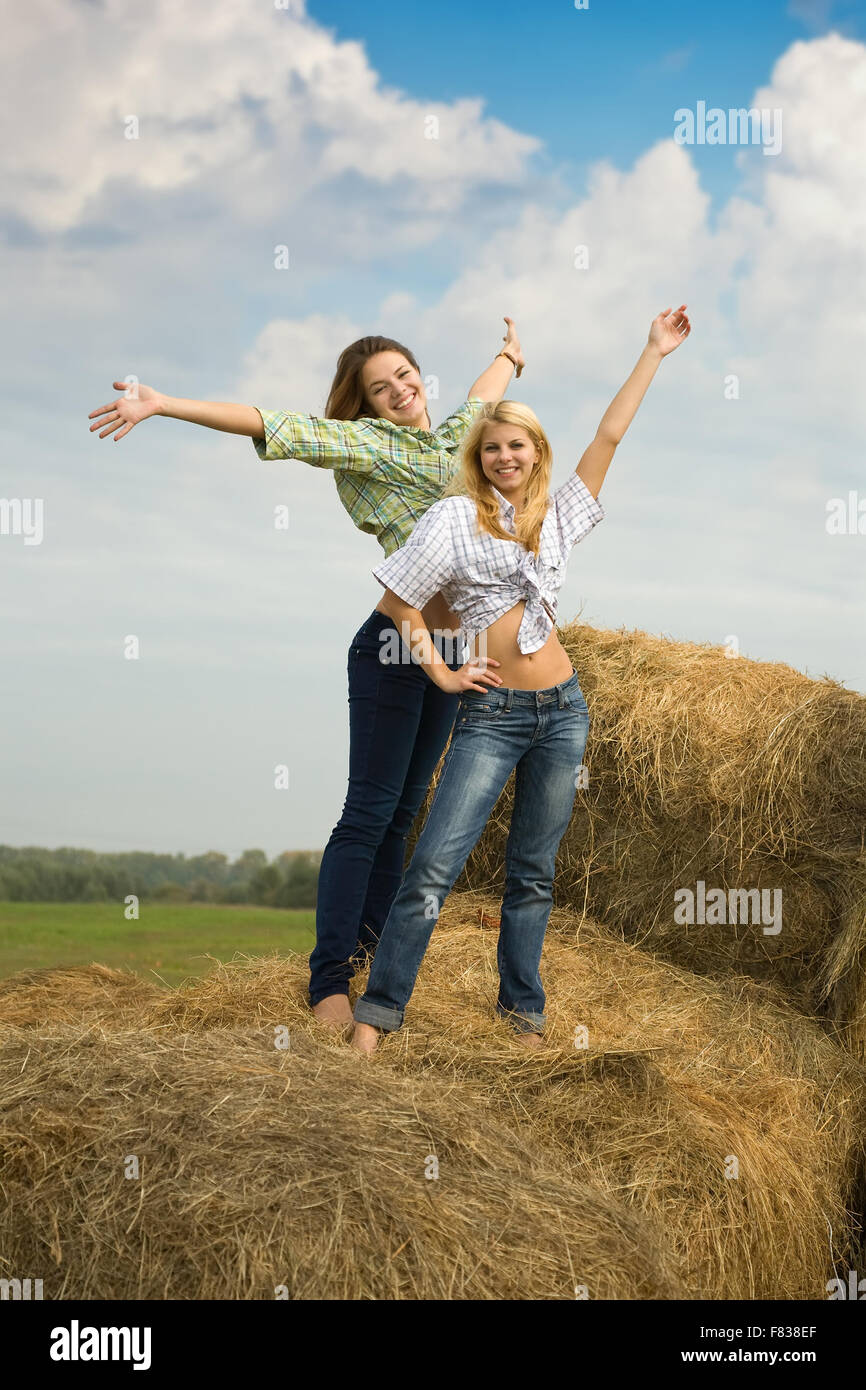 Young girls standing on top of hay bail Stock Photo - Alamy