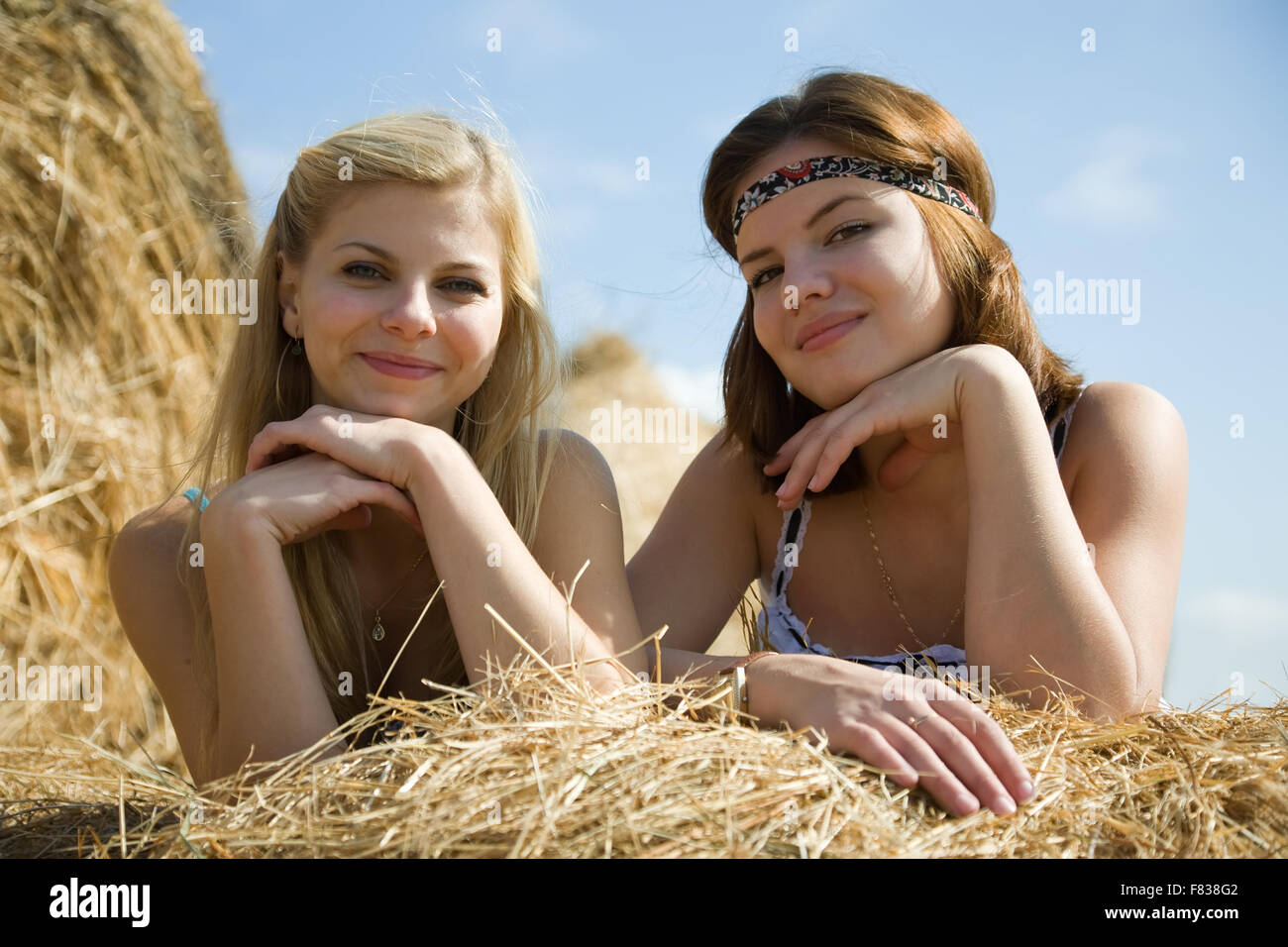 country girls resting on fresh hay bale Stock Photo - Alamy