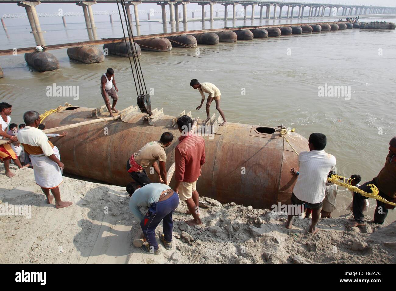 Laborers construct temporary pontoon bridge in the river Ganga ahead of ...
