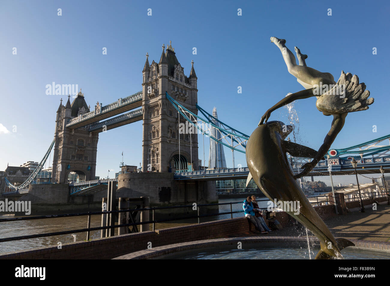 Girl and dolphin statue with Tower Bridge behind at London, UK Stock ...