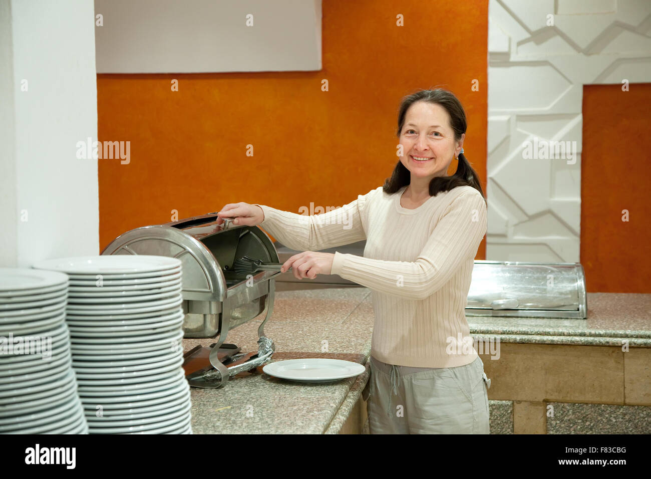 Female takes the meal on the buffet table Stock Photo - Alamy